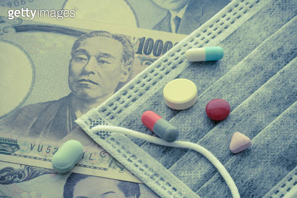 Gray face mask and medicine pill, tablets on Japanese yen bill banknote ...