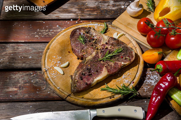 Grilled beef meat on the bone with cloves of garlic, tomatoes, red hot ...