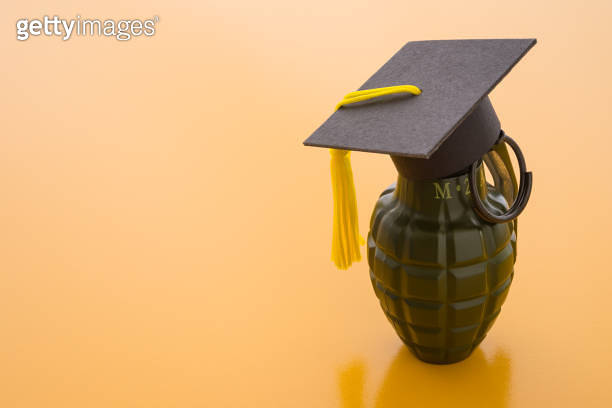 Graduation cap on hand bomb and yellow background. (1616489180) - 게티이미지뱅크