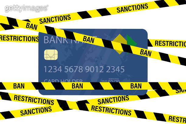 Bank card is covered with yellow warning tapes. Restrictions, ban on ...