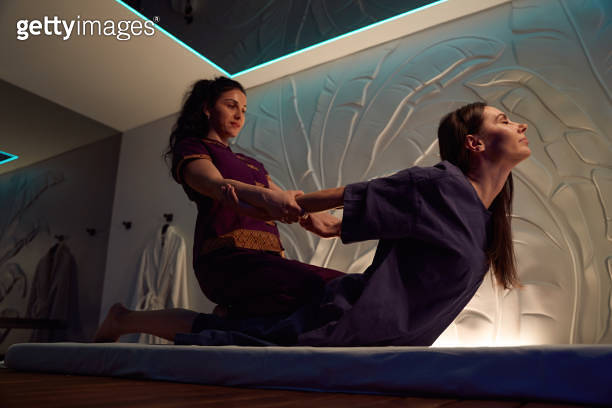 Experienced massotherapist stretching patient spinal muscles in Cobra ...