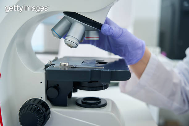 Laboratory employee works with a powerful microscope at the workplace ...