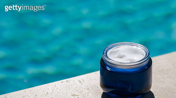Moisturising beauty cream, skincare and spa cosmetics by swimming pool ...