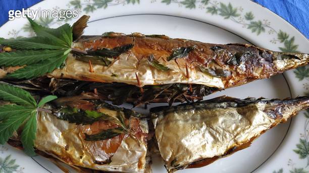cannabis (hemp) food. classic cannabis leaf lies on a baked fish ...