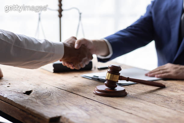 Businessman Shaking Hands In Front Of Mallet, justice and law concept ...