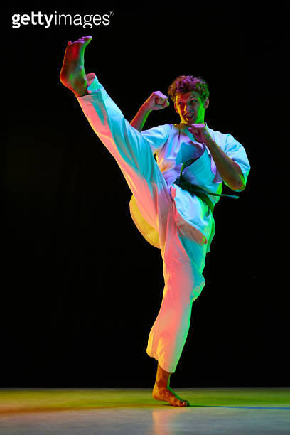 Professional combat sport. Young guy, karate athlete in motion ...