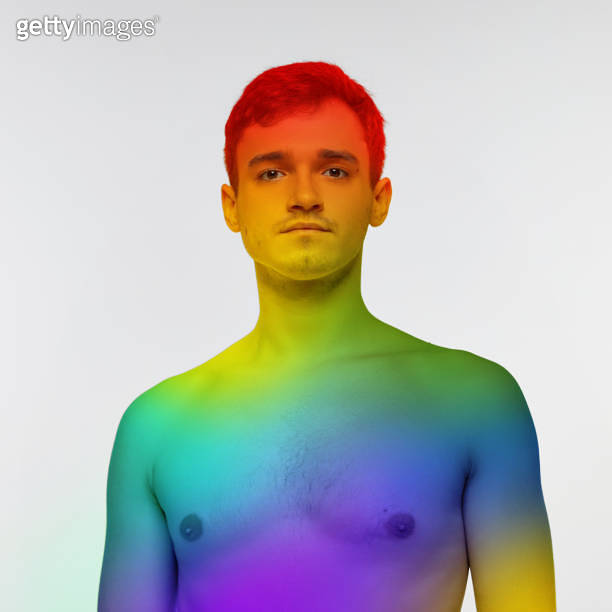 Portrait of young man posing shirtless with body colored in rainbow ...