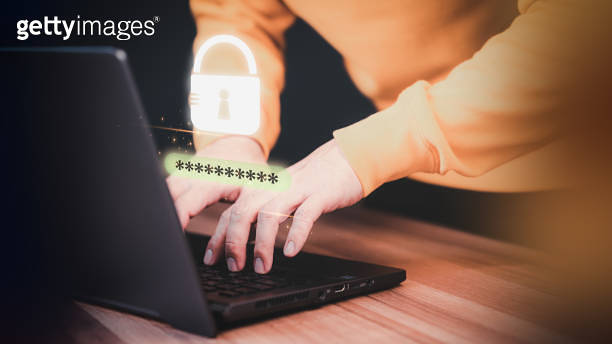 Adult man typing his user and password on a computer laptop. Cyber security concept to protect ...