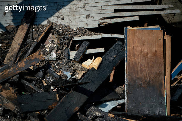 A burnt-out old wooden building after a fire. Charred beams after the ...