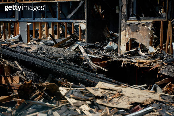 A burnt-out old wooden building after a fire. Charred beams after the ...
