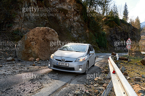 A huge rock fell from the mountains onto the road, destroying the ...