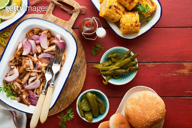 Pulled bbq chicken with baked onions on serving platter, bbq corn ...
