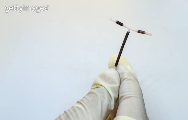 T-shaped intrauterine contraceptive device in gynecologist hand on ...