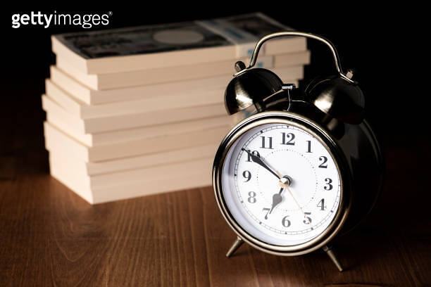 Alarm Clock with Stacked Banknotes (1660396478) - 게티이미지뱅크