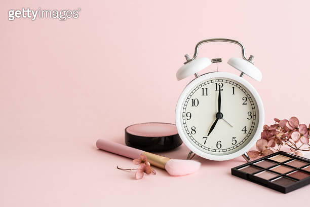 Cosmetics and an alarm clock. An image of women's makeup time. 이미지 ...