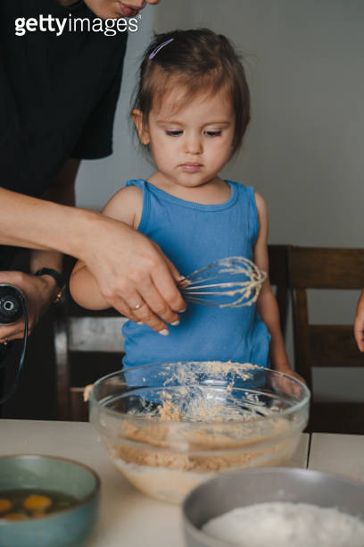 Caucasian family woman and young girl child daughter cooking, baking ...