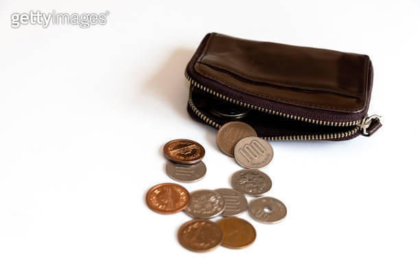 Coins spilled on the desk from a coin purse (1477683571) - 게티이미지뱅크