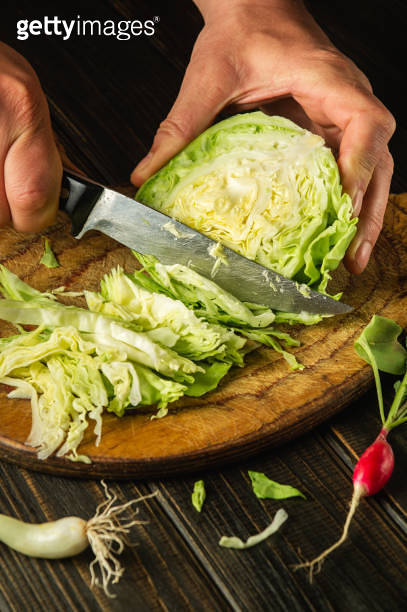 Cutting fresh cabbage by chef hands before preparing national or ...
