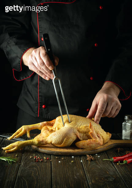 A dish of fried chicken by the hands of the chef in the kitchen of the ...