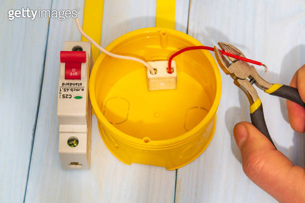 Master Electrician Cuts Red Wire Using Wire Cutters (1457154579) - 게티이미지뱅크