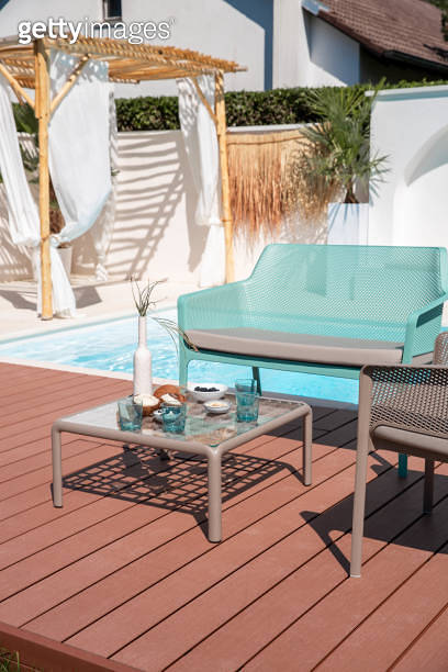 Outdoor garden living space pool area with sofa couch, table and ...