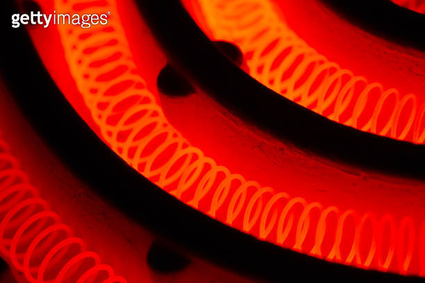 Red hot electric stove nichrome wire coil for cooking, close up macro ...