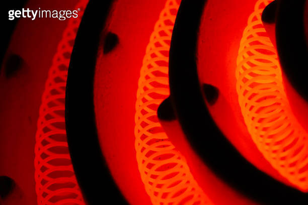 Red hot electric stove nichrome wire coil for cooking, close up macro ...