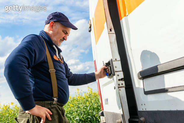 Mature van driver gets into his delivery van to check on the delivery ...