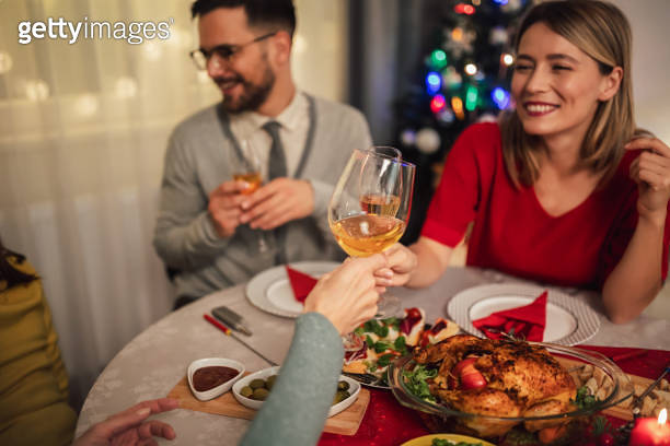 Couple drinking wine and laughing while sitting around a dining table ...