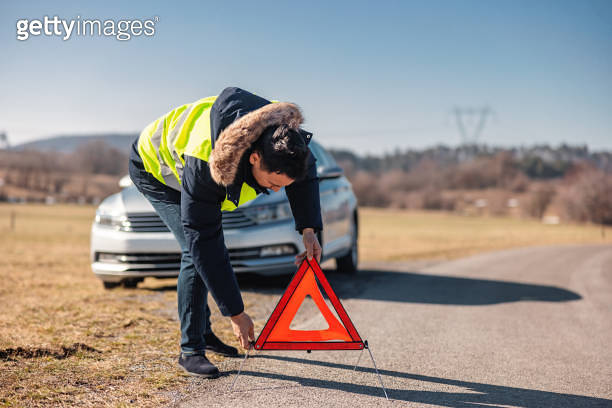 Man Putting Down A Red Warning Triangle 이미지 (1471589161) - 게티이미지뱅크