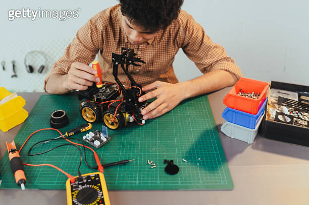 Asian young man assembling a robotic car, focus on robotics, assembling ...