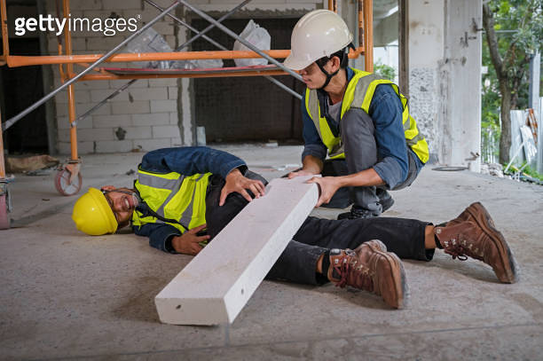 Young Asian builder falls from a height at a construction site. An ...