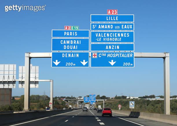 Road signs with French locations in the wide highway with three lanes ...