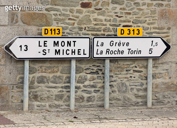 French road signs with directions to Mont Saint Michel at 13 km and ...