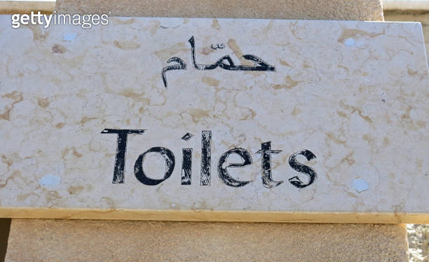 Bilingual text in Arabic and English indicating the Toilets 이미지 ...