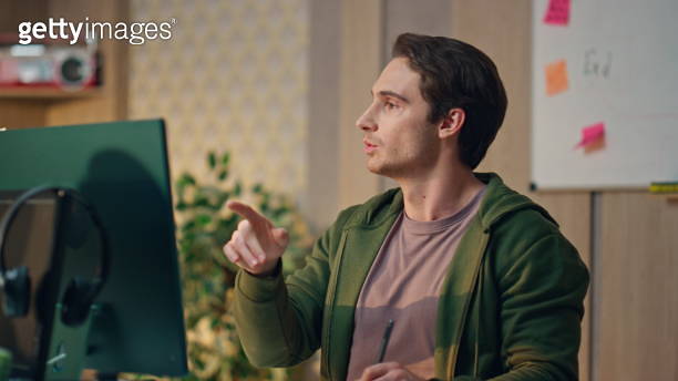 Talking freelancer watching monitor at workplace close up. Guy staring ...