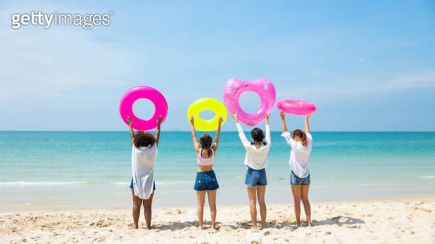float. Group of teenager girls walking to the beach. Four teenager girl ...