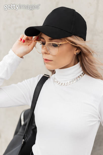 Stylish beautiful young girl with glasses and a black cap wearing a ...