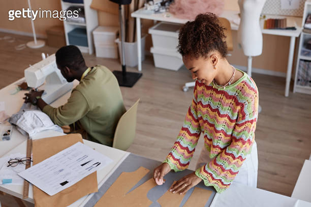 Young African American woman working with paper sewing patterns 이미지 ...