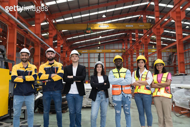 Group of male and female factory workers standing together with crossed ...