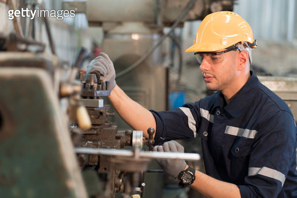 Male factory worker working at work maintenance machine in industrial ...
