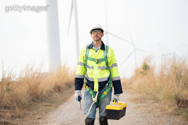 Male engineer working with plan maintenance of wind turbines at ...