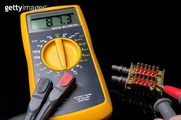 Electronics, close-up of a digital multimeter with its tips measuring ...