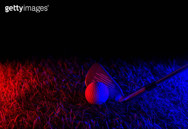Golf stick and white ball on grass with neon lighting. Blue neon banner ...