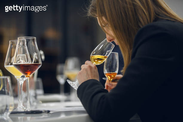 Wine waiter woman during blind tasting various alcoholic beverages ...