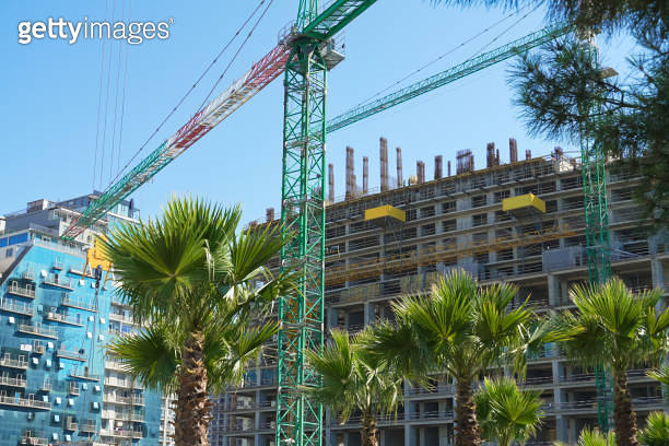 Close-up of a construction crane against the background of buildings ...