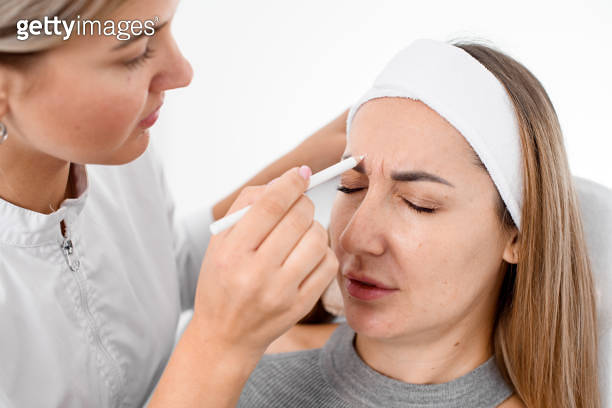 beautician accurate makes marks on female face for botox injection ...