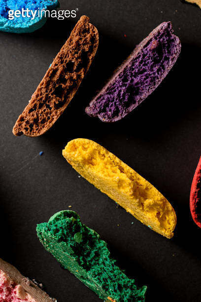 Colorful crushed halves of macaroons on dark concrete background. Top ...