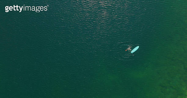 Aerial view of stand up paddle boarder (SUP) enjoys tranquil moments on ...