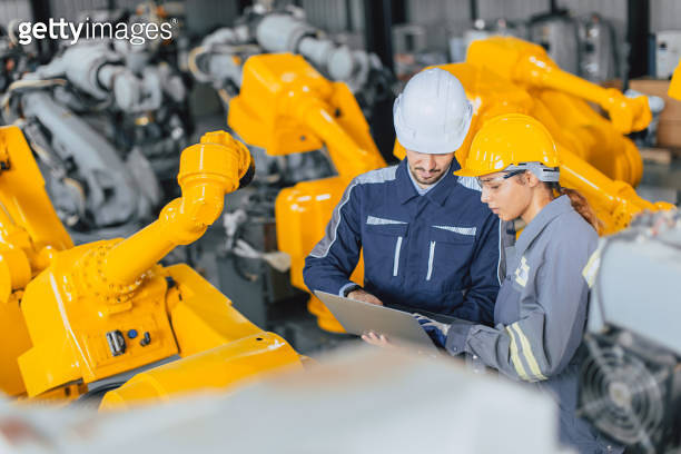 engineer team working together inspection quality robot arm in robot assembly industry plant ...